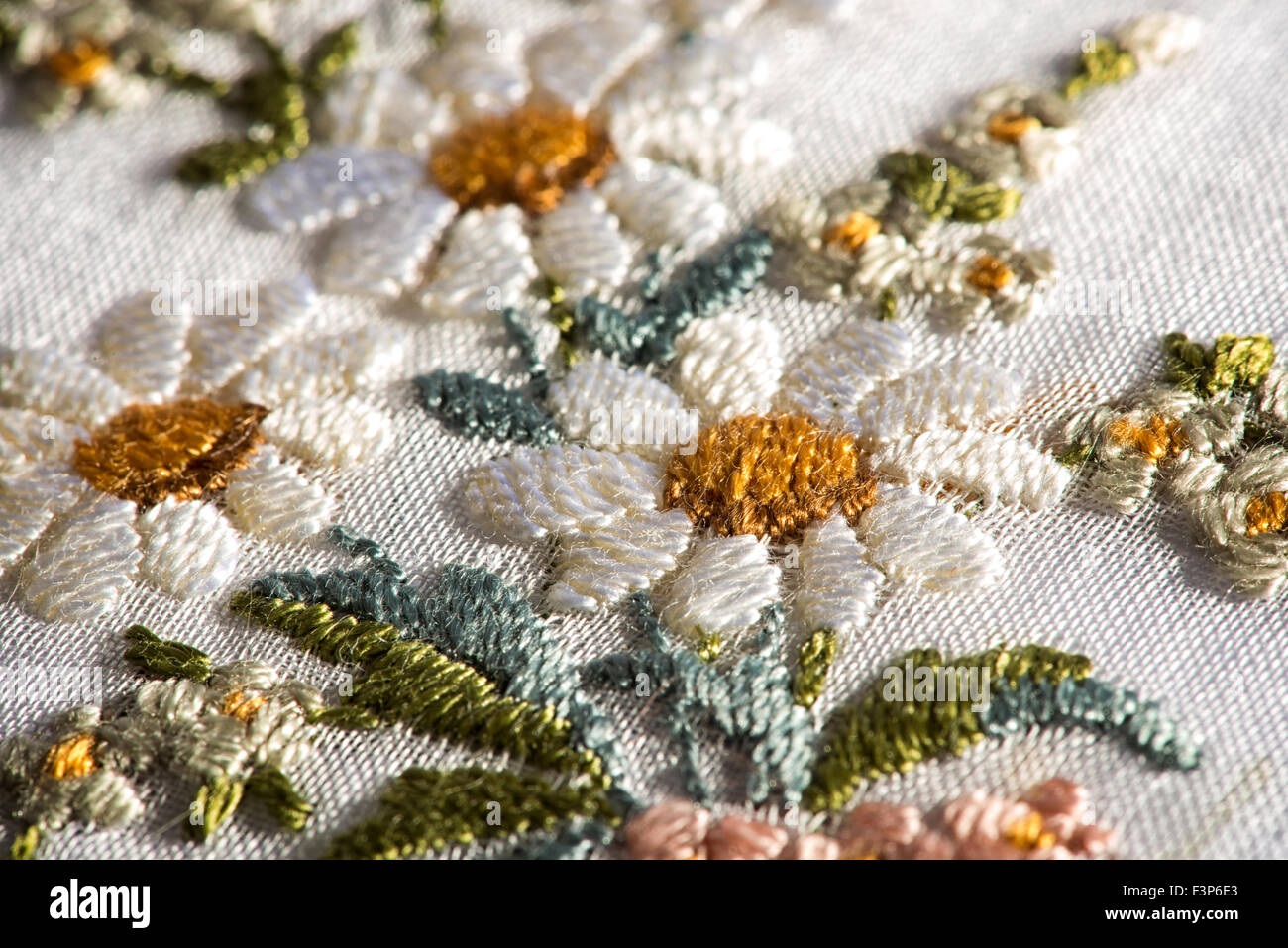 Detail of floral embroidery depicting white spring daisies on a textile ...