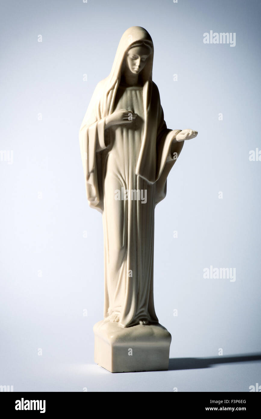 Statue of the Virgin Mary on a gray background depicting humility and ...