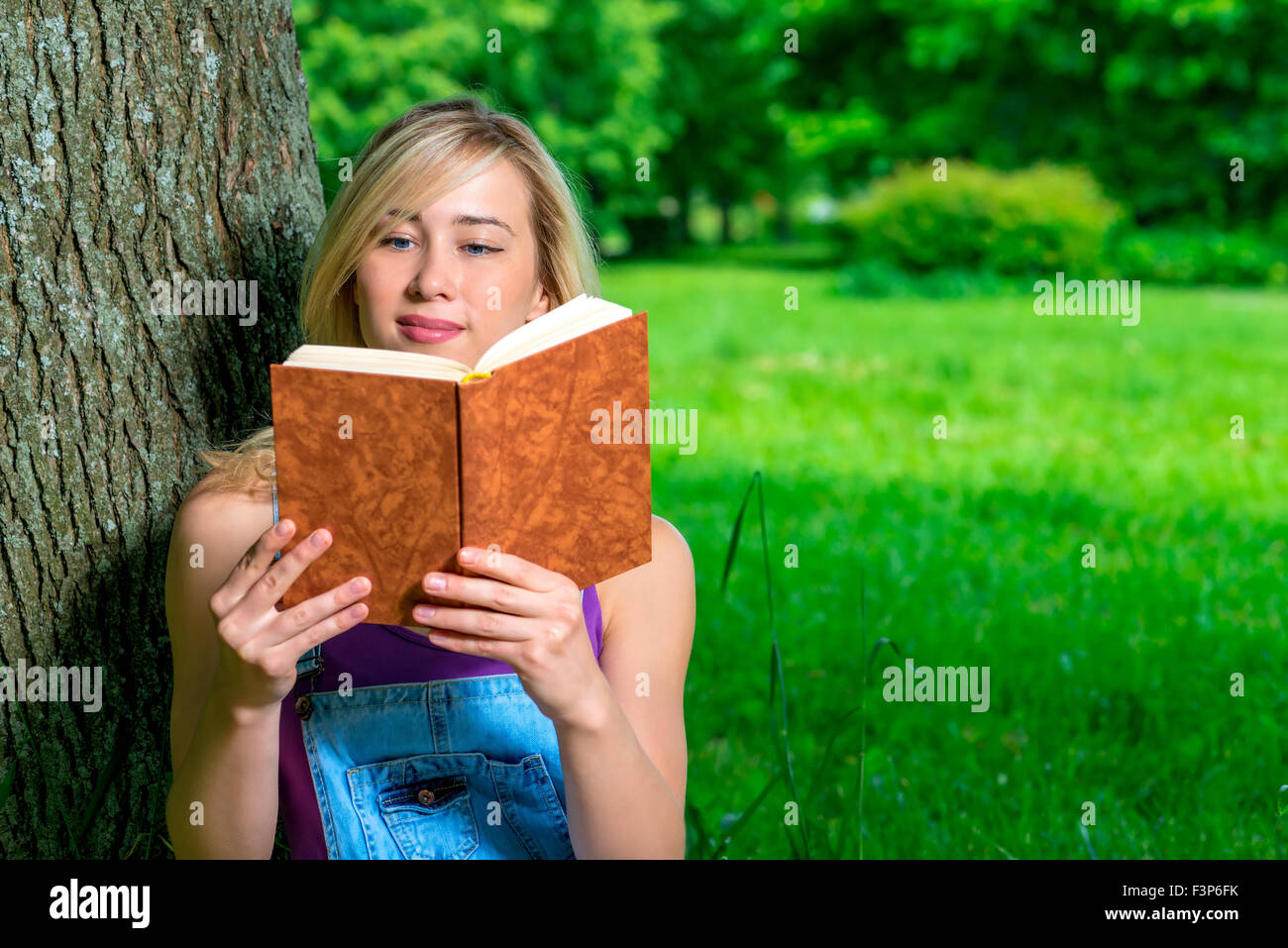 beautiful girl reading an interesting book in the summer park Stock ...