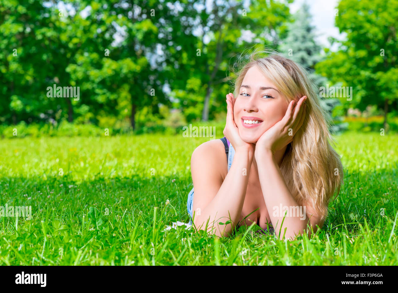 girl with a beautiful smile posing lying on the grass Stock Photo - Alamy