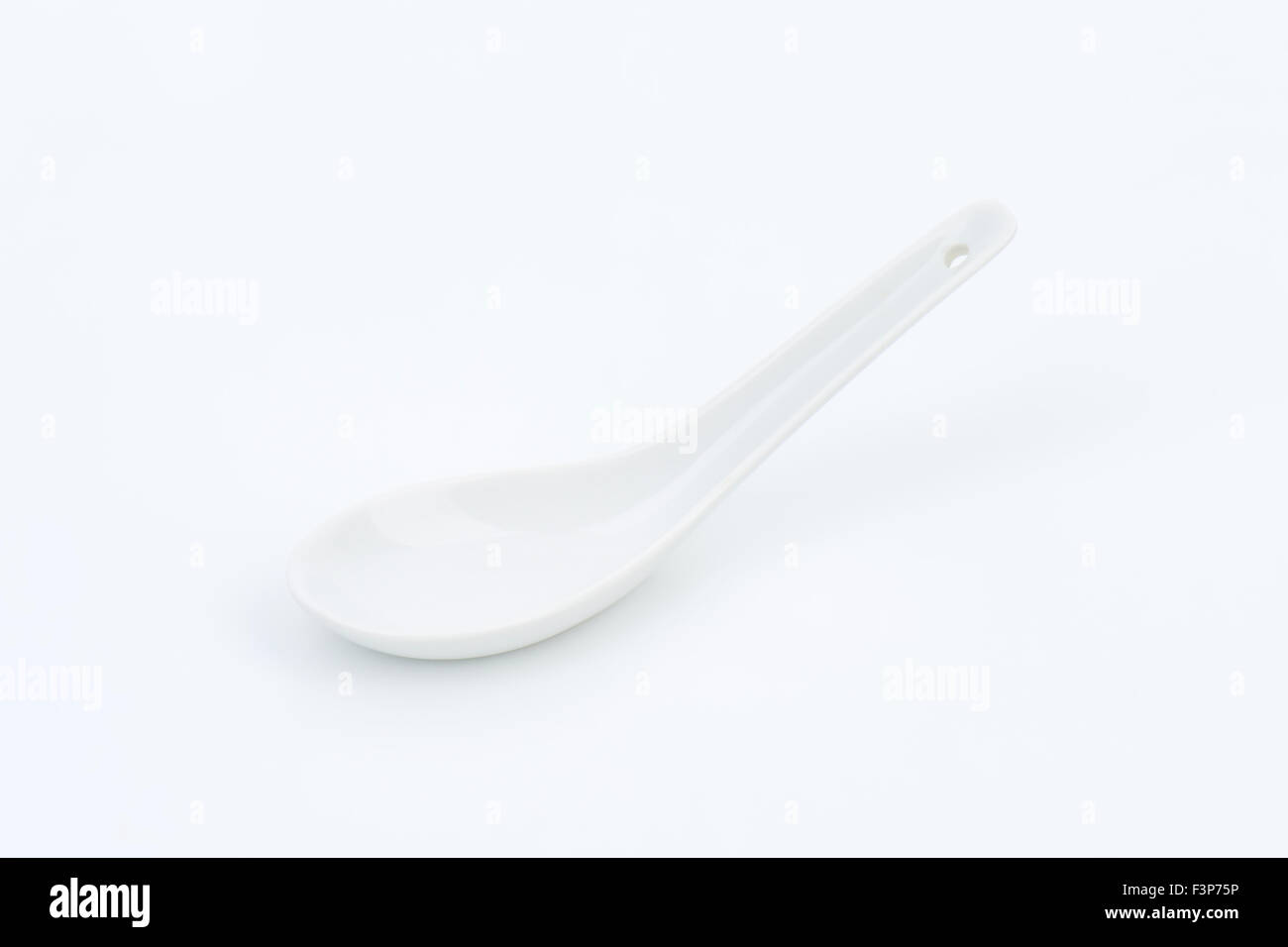 white ceramic spoon on white background Stock Photo - Alamy