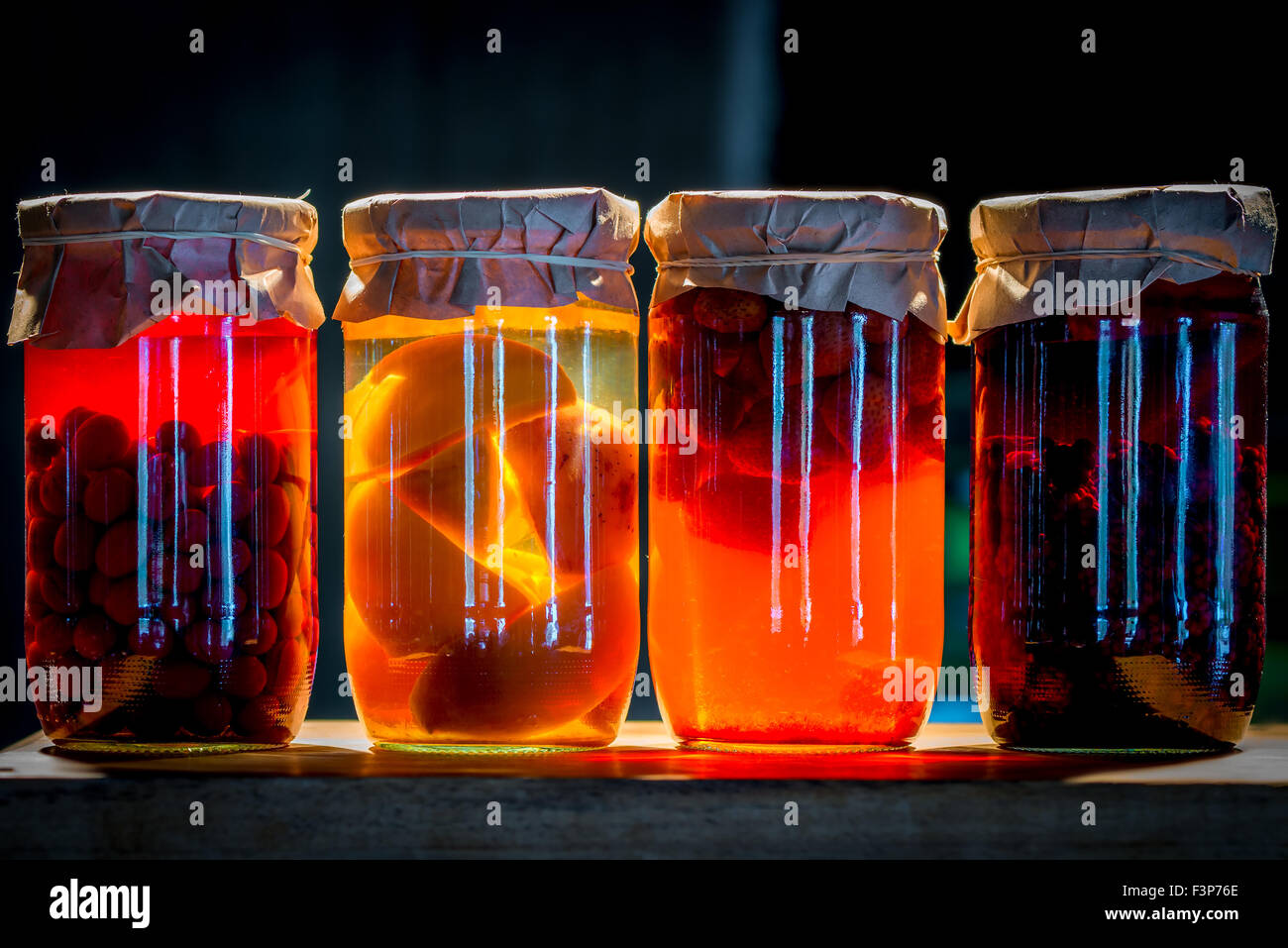 Four cans of compote fruit and berries illuminated Stock Photo - Alamy