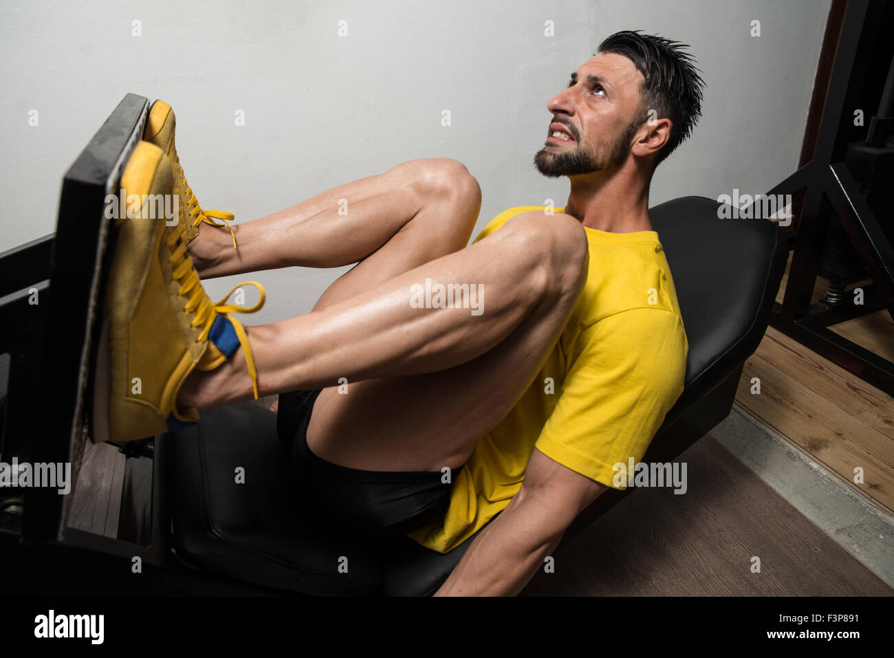 Fit Man Using The Leg Press Machine At A Health Club Stock Photo - Alamy