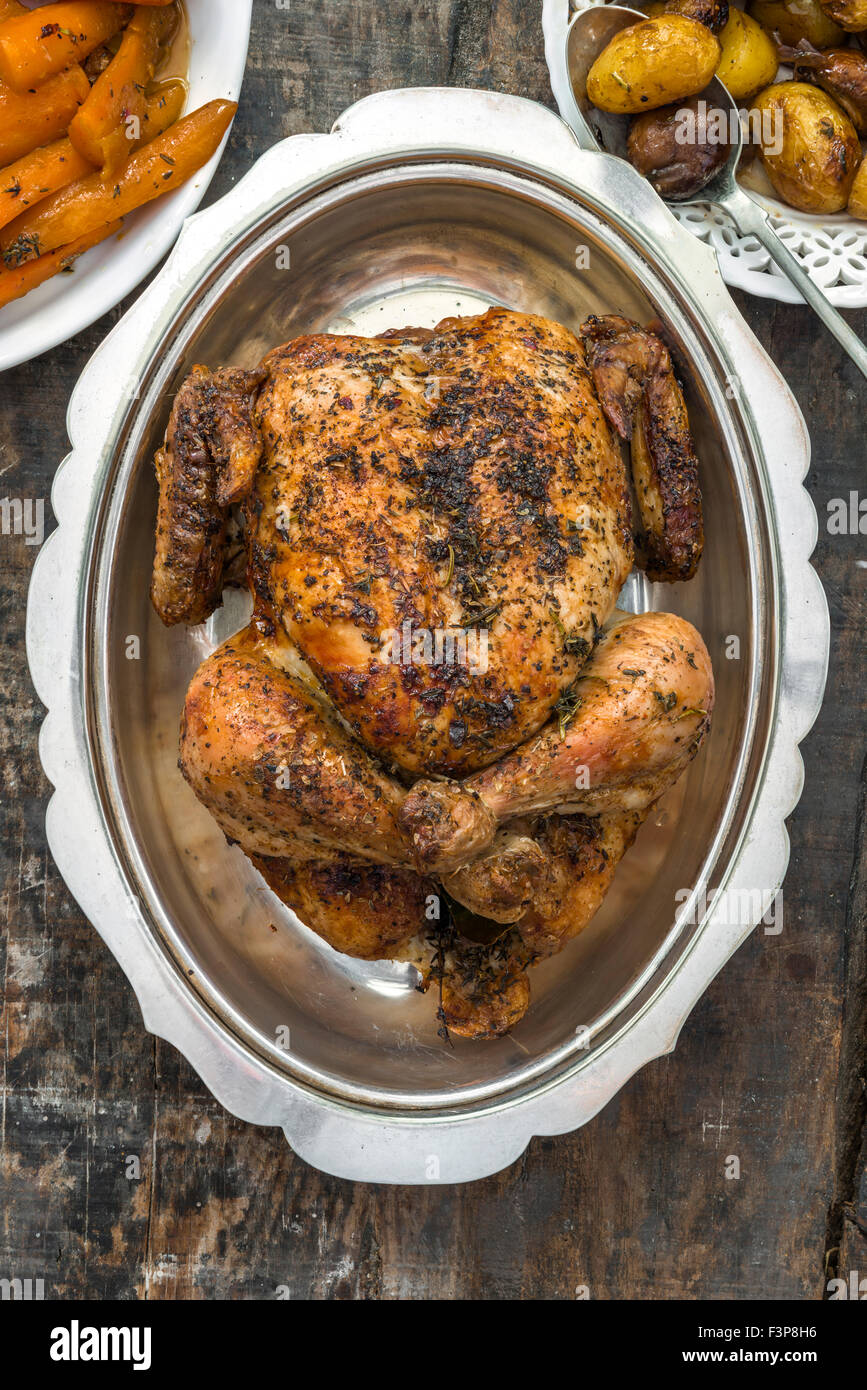 Roast chicken on rustic wooden table - top view Stock Photo - Alamy
