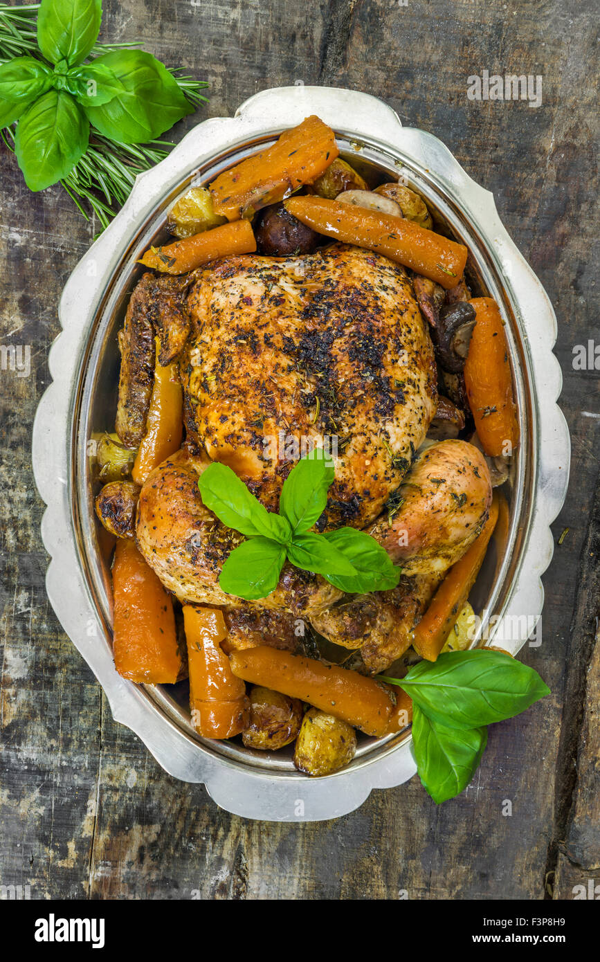Roast chicken on rustic wooden table - top view Stock Photo - Alamy