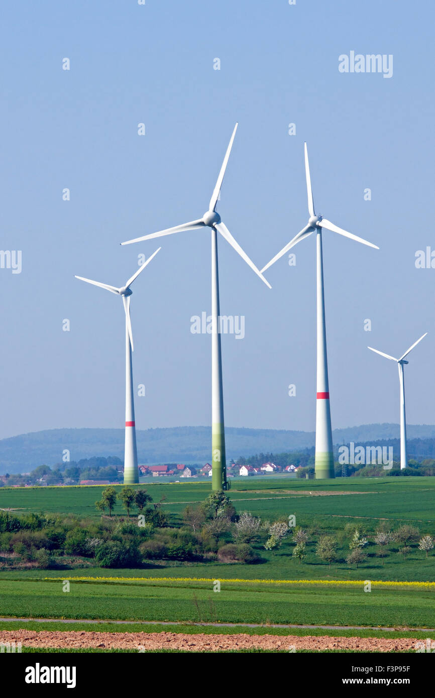 Four windwheels in the fields with a village in the back Stock Photo ...