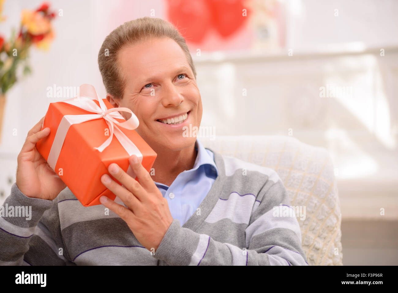 Nice man holding present Stock Photo - Alamy