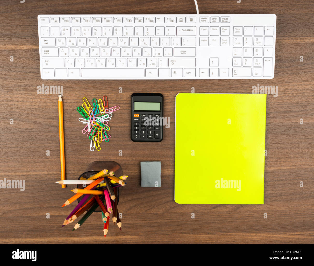 Keyboard with office supplies on table Stock Photo - Alamy