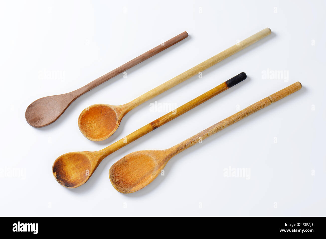 four wooden spoons on white background Stock Photo - Alamy