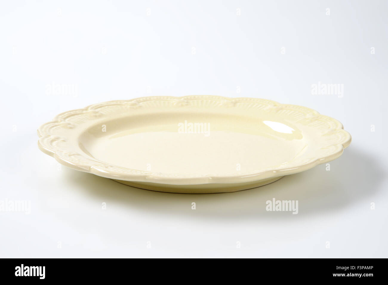 beige decorative plate on white background Stock Photo - Alamy