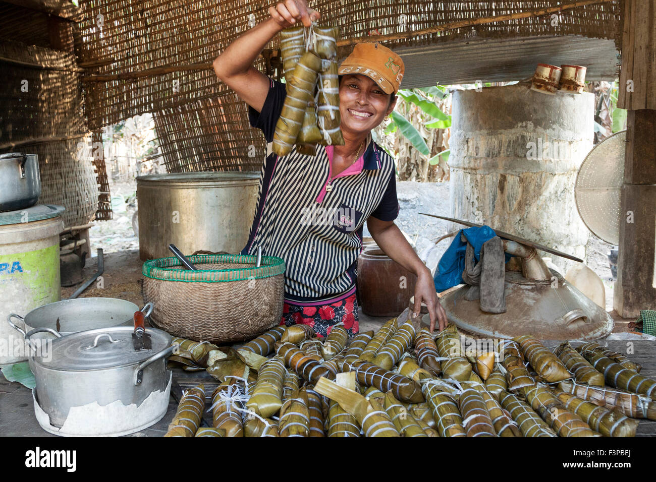 A woman cooking Rice ingots, wrapped in banana leaves - traditional ...