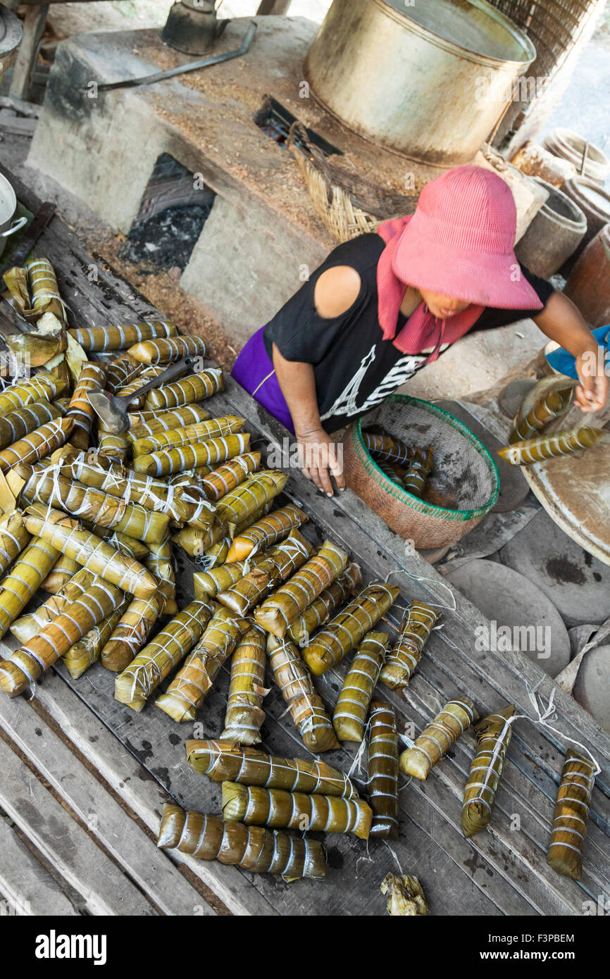 A woman cooking Rice ingots, wrapped in banana leaves - traditional ...