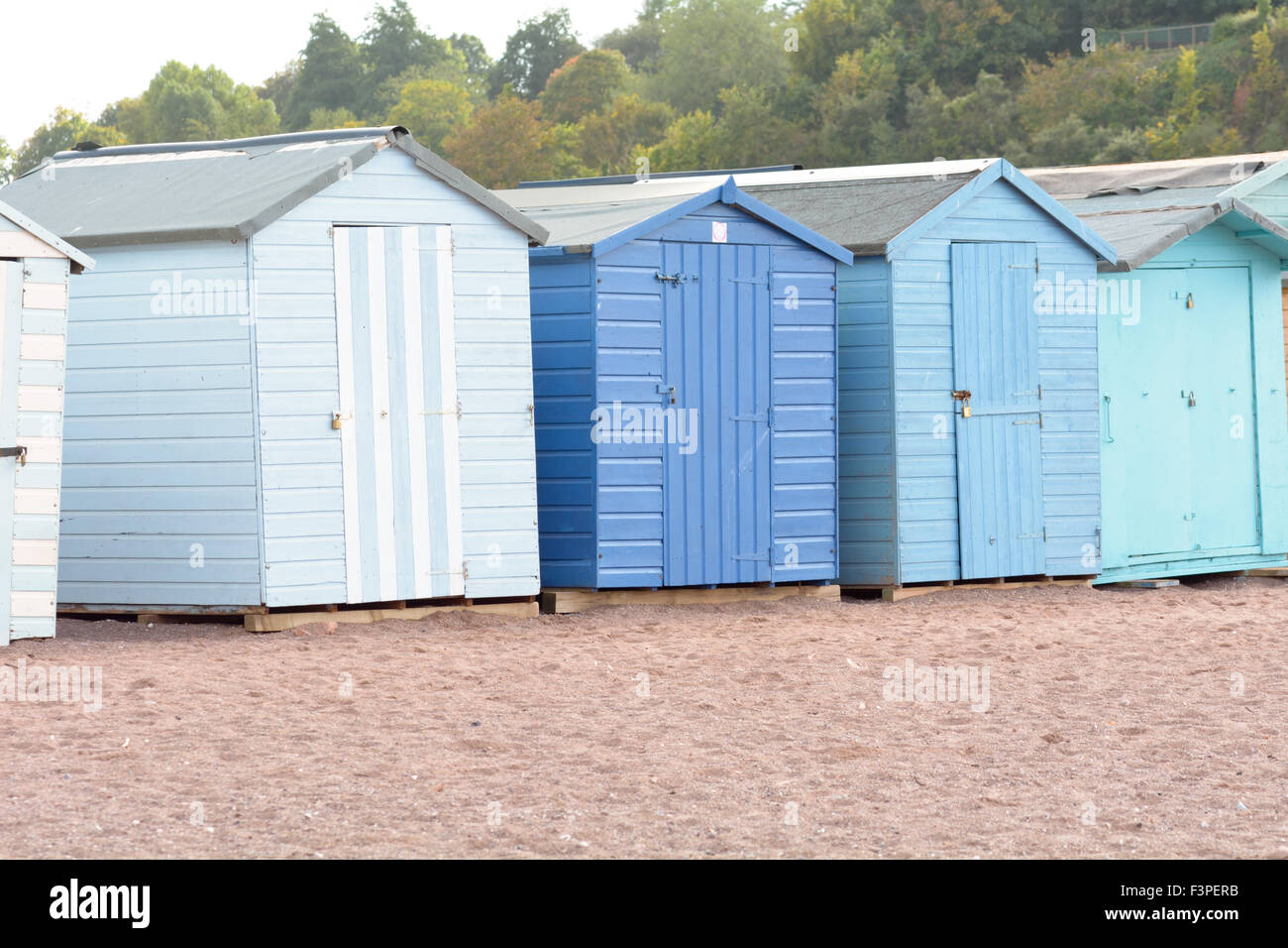 A line of wooden beach hut on the back beach in Teignmouth, Devon ...