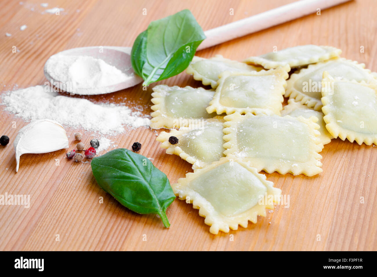 Raw ravioli with flour on wooden table Stock Photo - Alamy