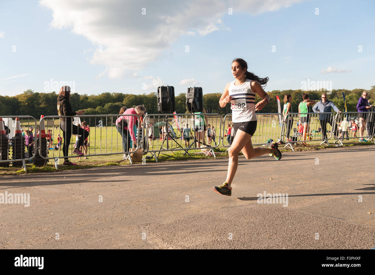 Young lady sprinting and running to the finish line in a cross country ...