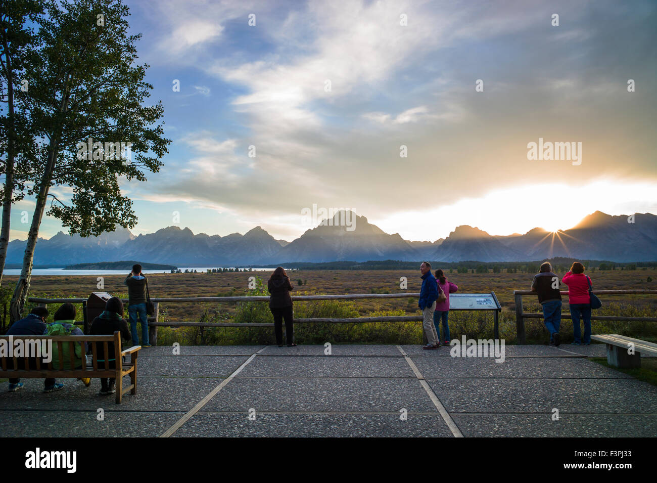 Tourists enjoy sunset view from patio of famous & historic Jackson Lake ...