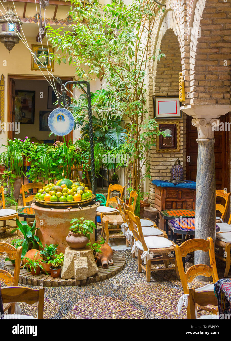 typical Andalusian courtyard decorated with flowers arches and columns ...