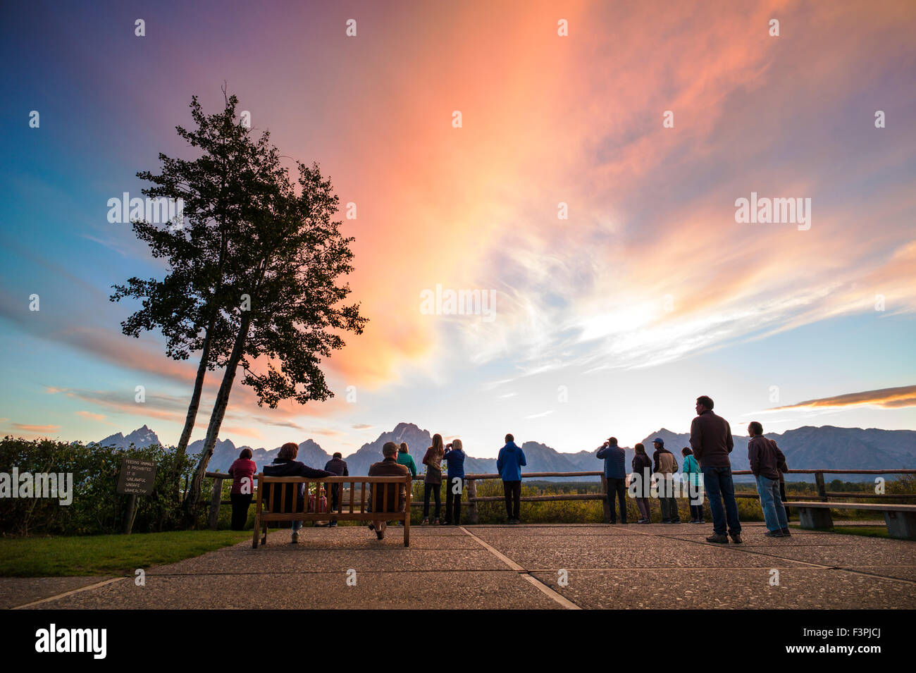 Tourists enjoy sunset view from patio of famous & historic Jackson Lake ...