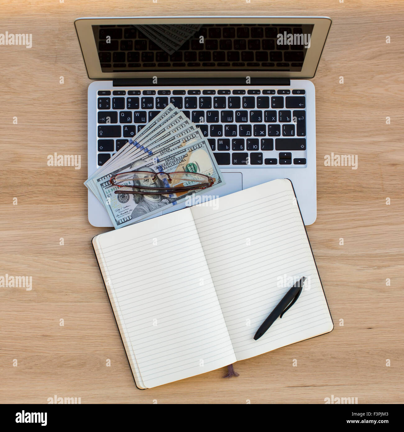 Laptop, dollars bills, and an open notebook with space for your text ...