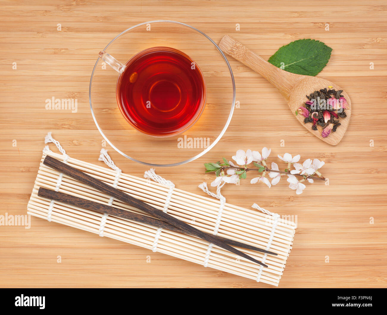 Japanese green tea and sakura branch over mat and bamboo table Stock ...