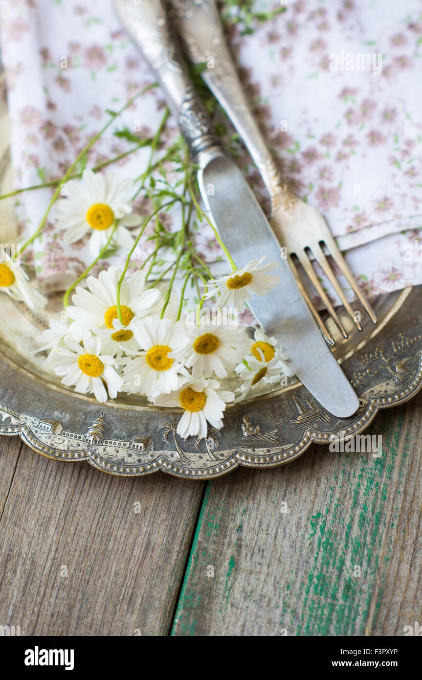 Summertime Table Setting with daisy flowers, napkin and silverware on ...