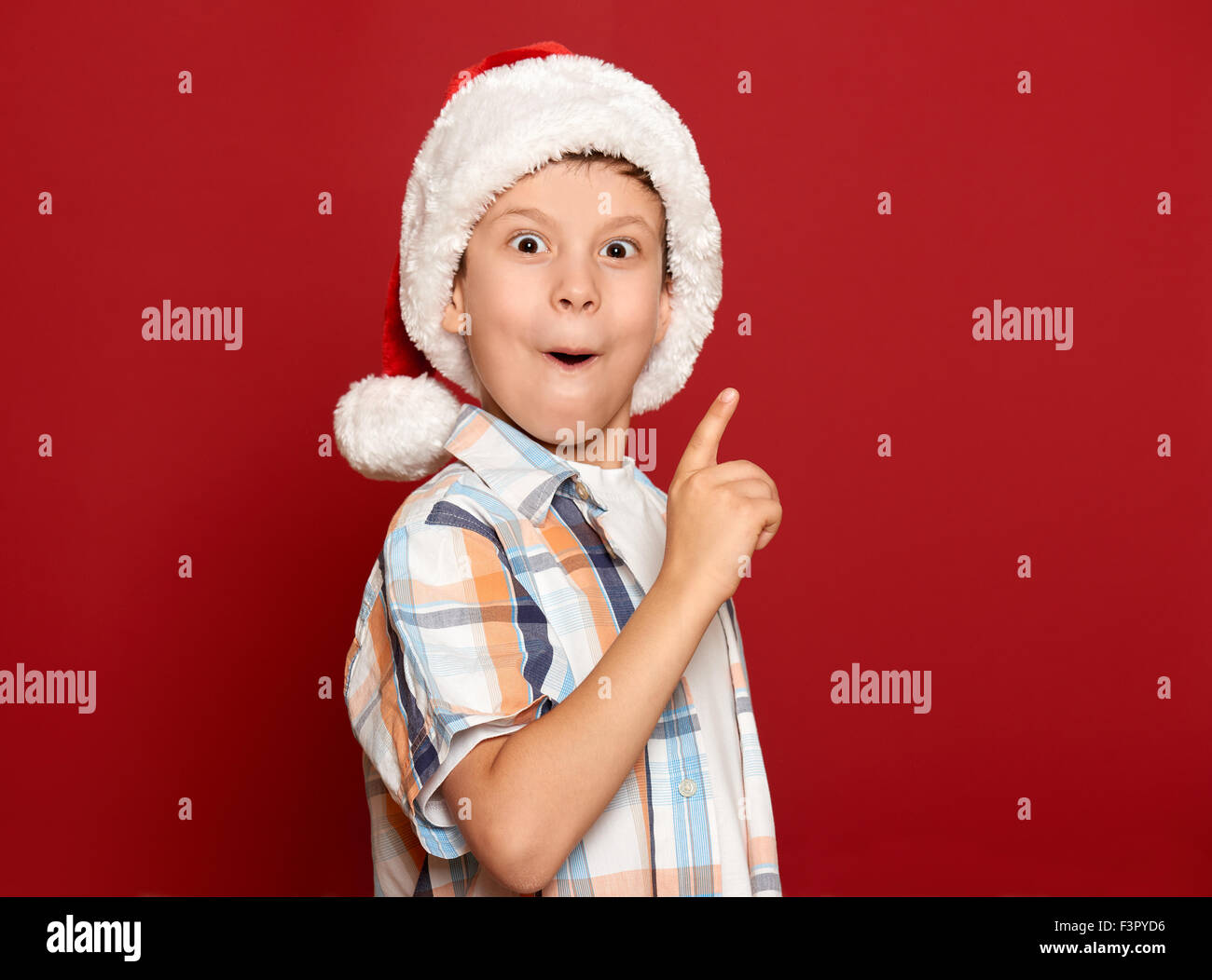 winter holiday christmas concept - boy in santa helper hat have idea on ...