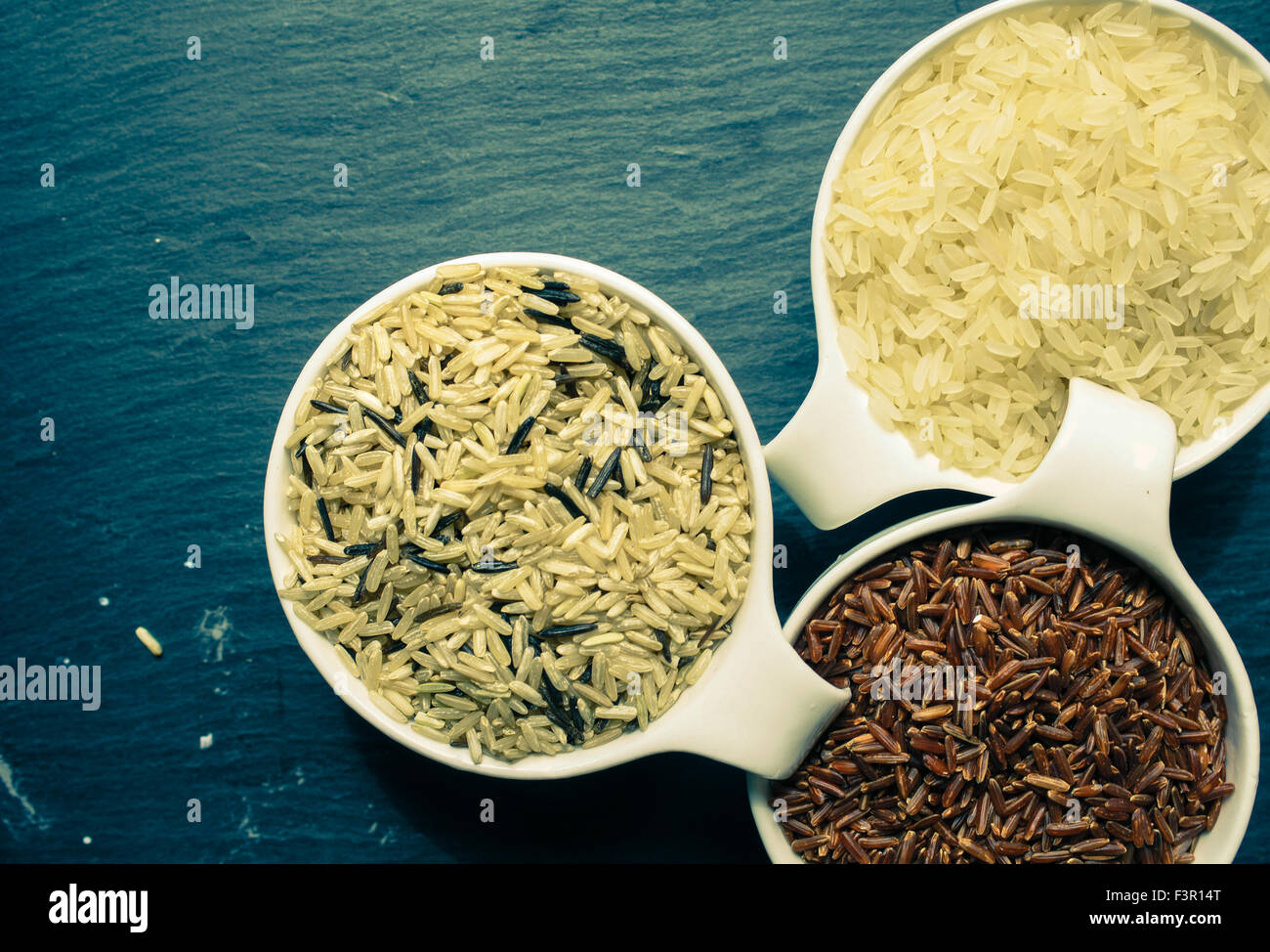 Different kinds of rice in the pots on the rustic table Stock Photo - Alamy