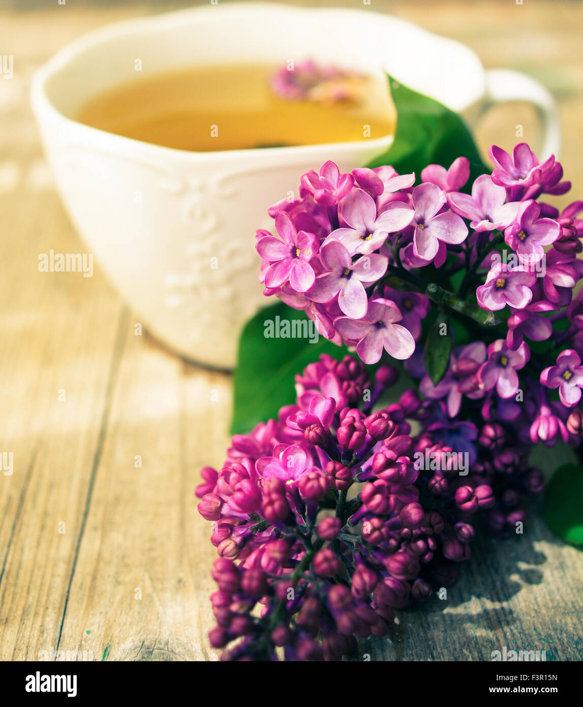 Lilac flowers in a pot and cup of tea in rustic interior Stock Photo ...