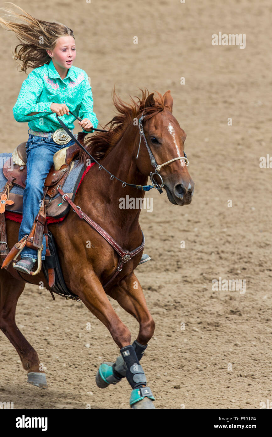 Rodeo cowgirl on horseback competing in barrel racing event, Chaffee ...