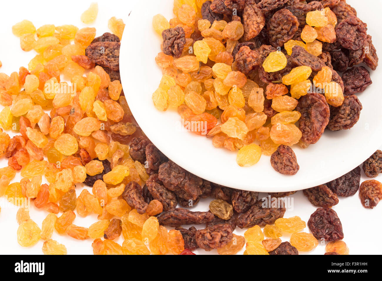 Raisins in aplate and scattered around him Stock Photo - Alamy