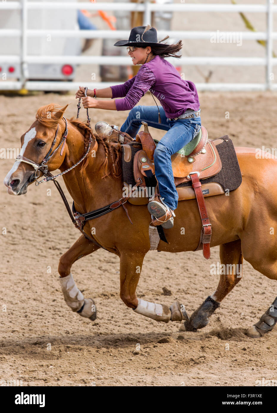 Rodeo cowgirl on horseback competing in barrel racing event, Chaffee ...