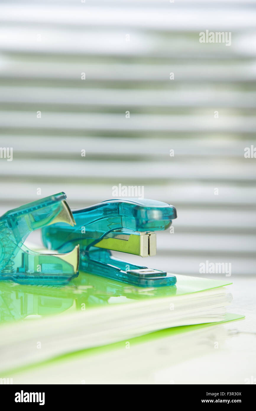 green stapler,staple remover on a green folder Stock Photo - Alamy