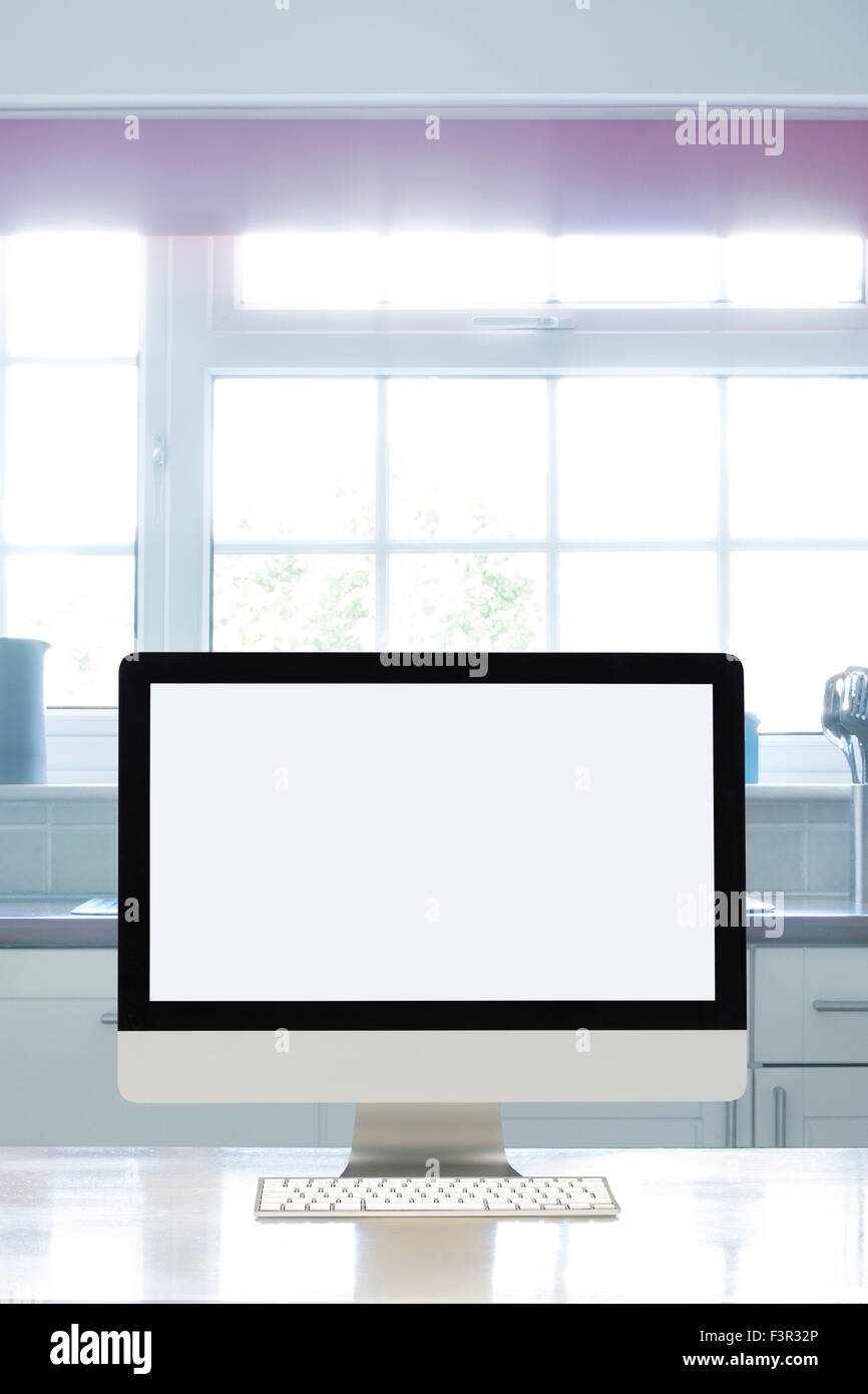 Home office interior set up in kitchen with a blank computer screen to ...