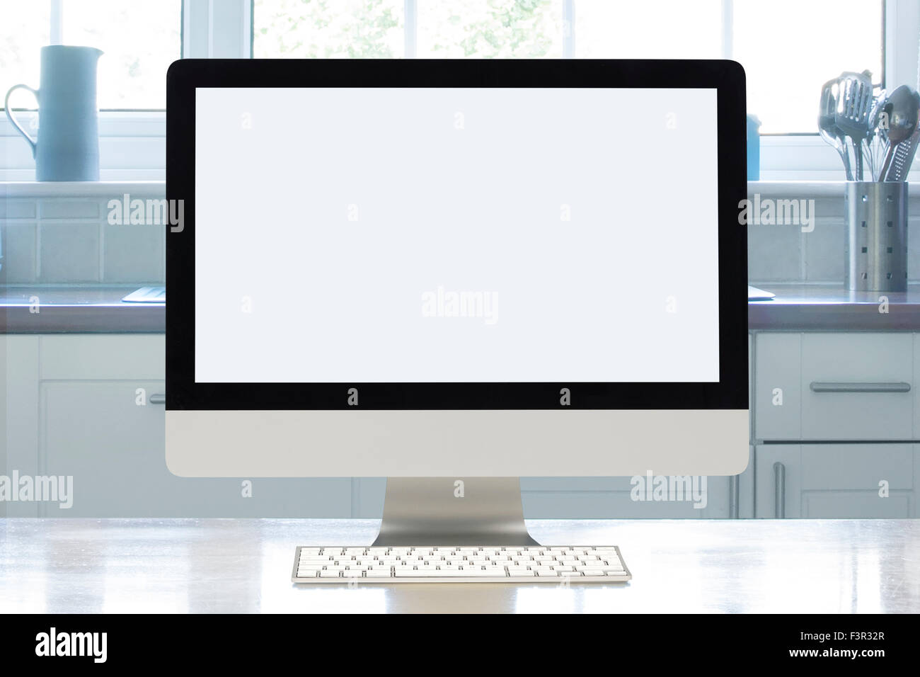 Home office interior set up in kitchen with a blank computer screen to ...