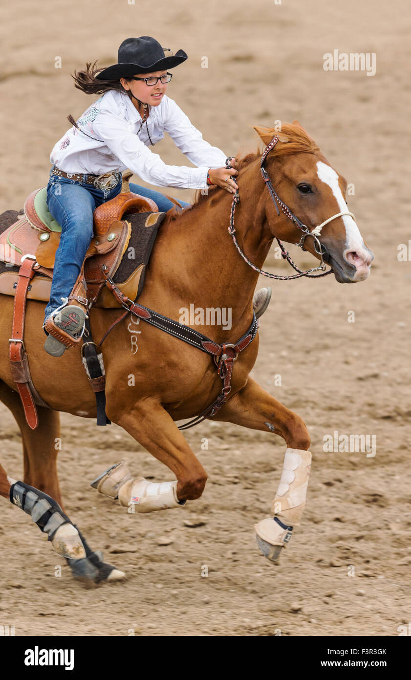 Rodeo cowgirl on horseback competing in barrel racing event, Chaffee ...