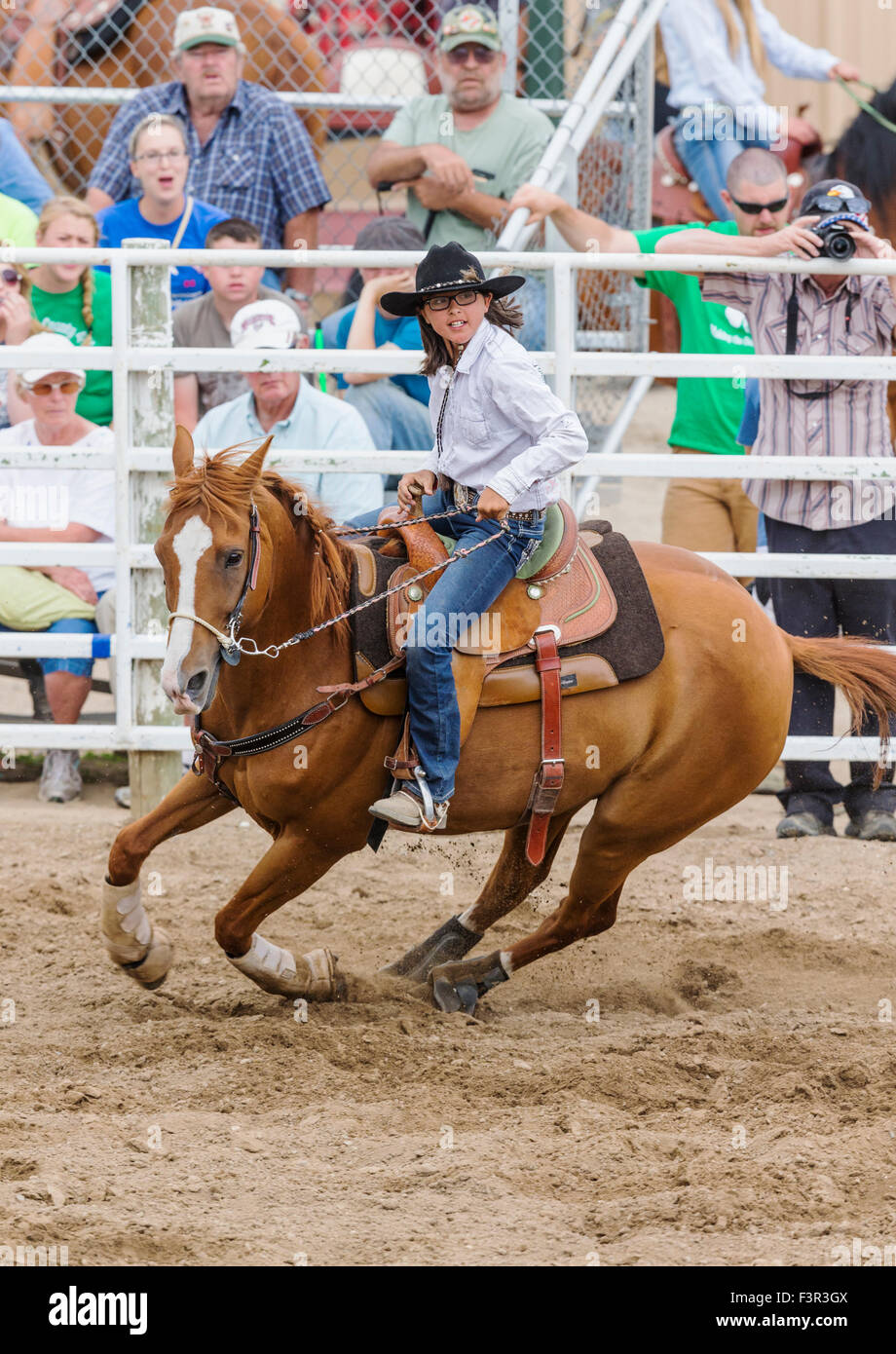 Rodeo cowgirl on horseback competing in barrel racing event, Chaffee ...
