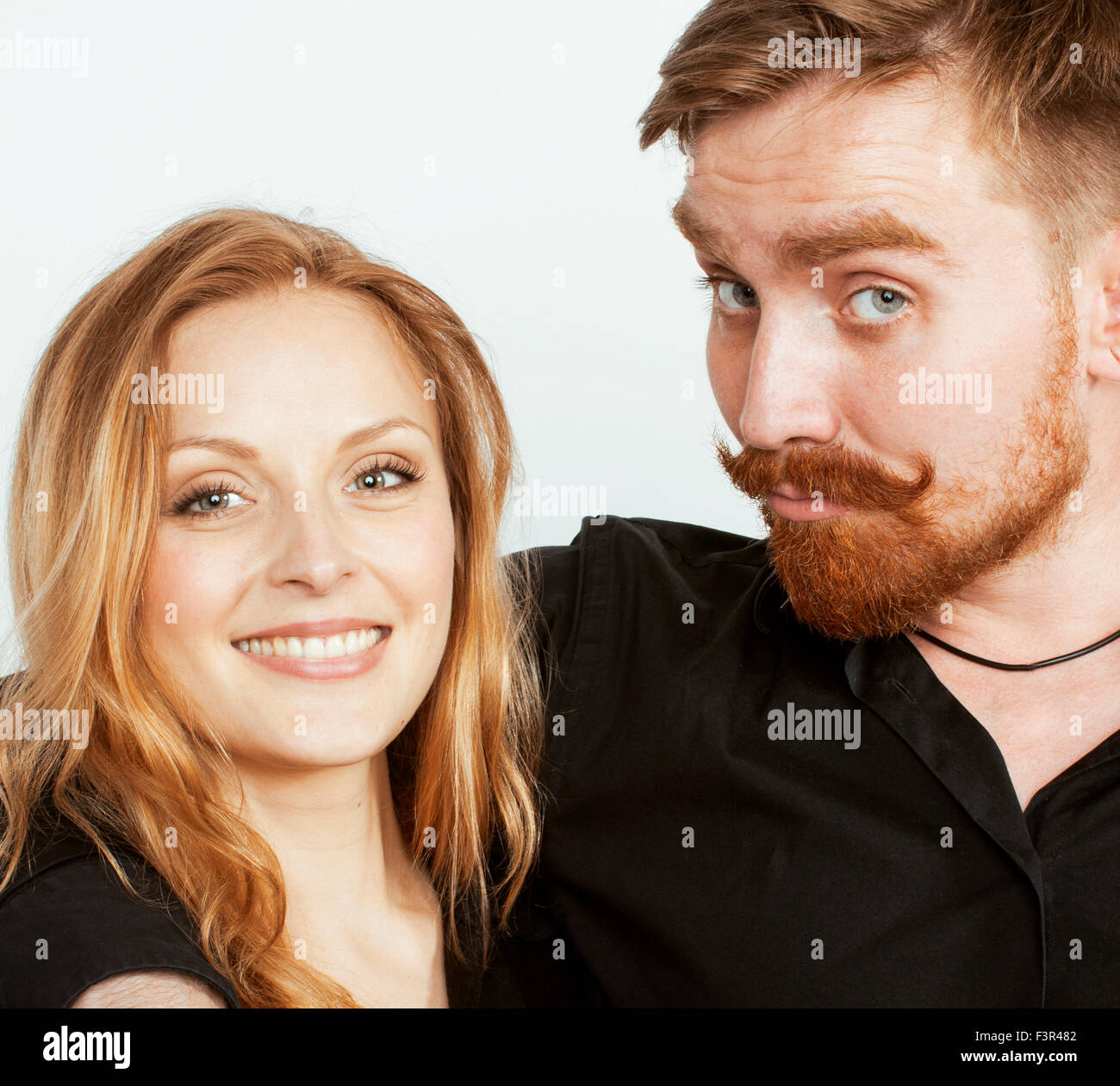 young hipster couple fooling around on white background close up, both ...
