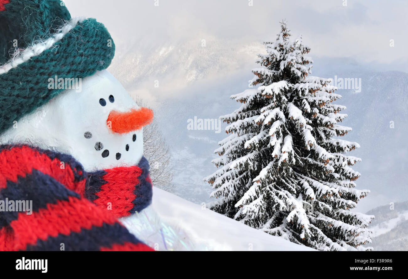 snowman on snowy mountain background with fir Stock Photo - Alamy