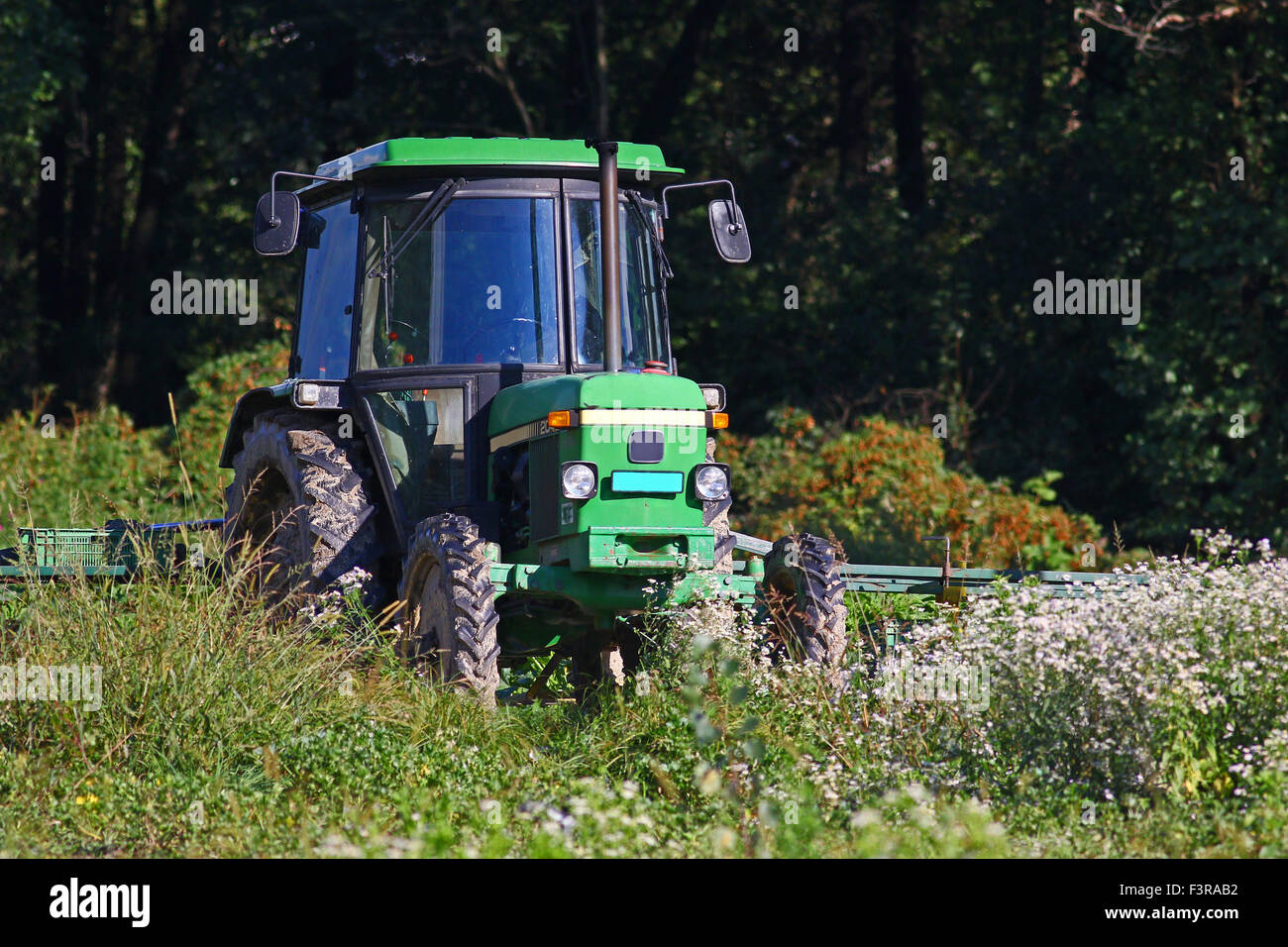 Green tractor in the field in a farming community Stock Photo - Alamy