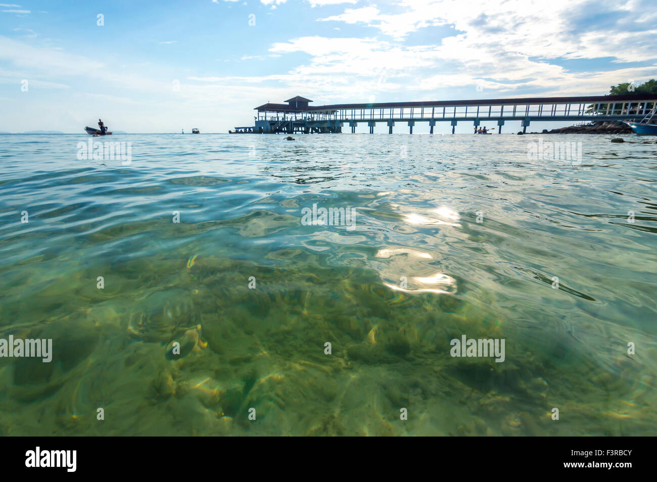Clear water with jetty and blue skies Stock Photo - Alamy