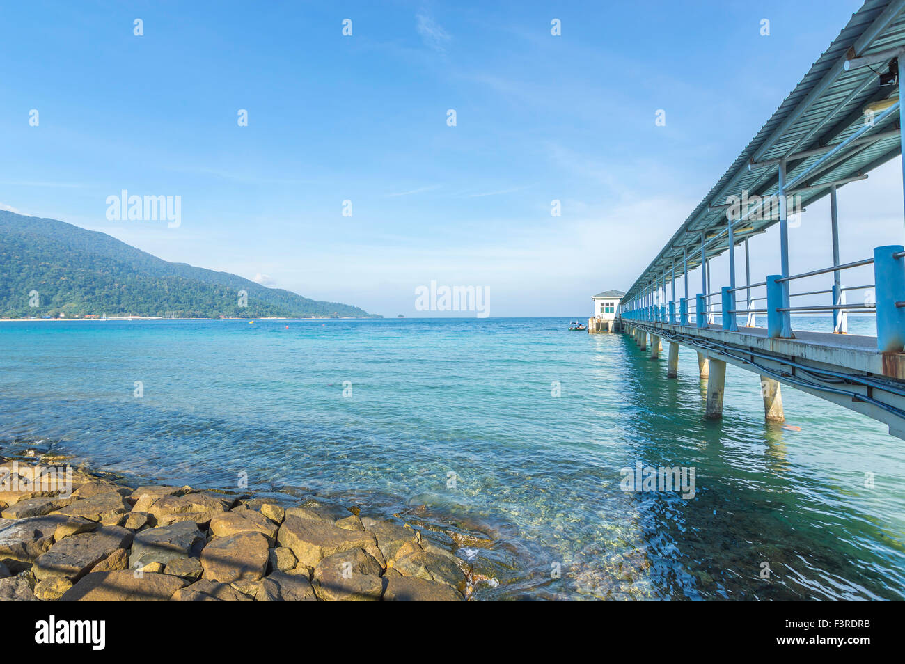 Jetty with clear water and blue skies Stock Photo - Alamy