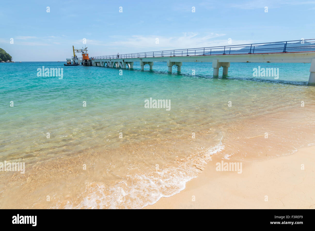 Jetty with clear water and blue skies Stock Photo - Alamy