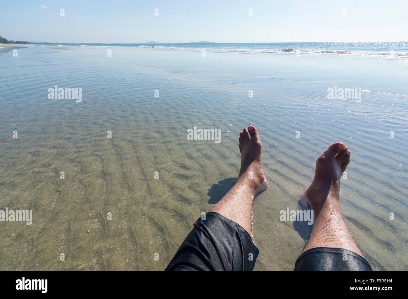 Man legs on the beach with direct sunlight Stock Photo - Alamy