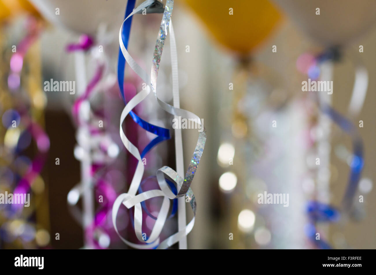 Shiny decorative ribbons hanging from helium balloons Stock Photo - Alamy