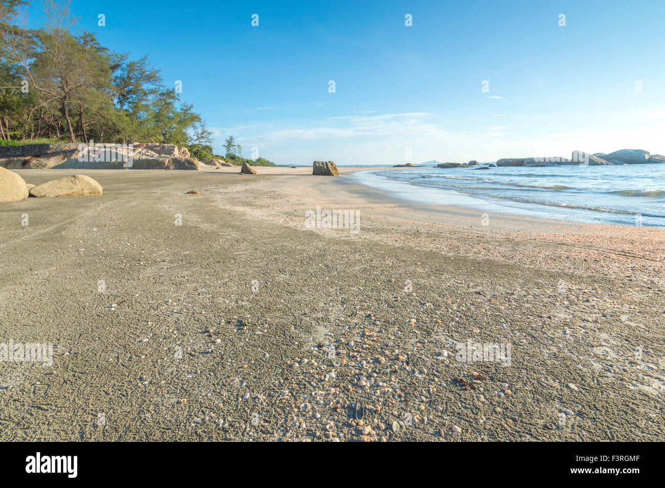 Yellow sand at sea shore withrock and blue skies background Stock Photo ...