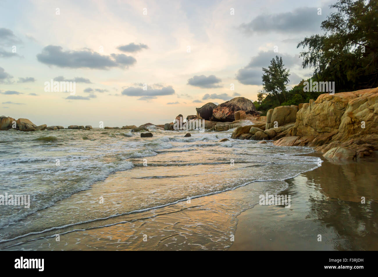 Beach rock with sunset background Stock Photo - Alamy
