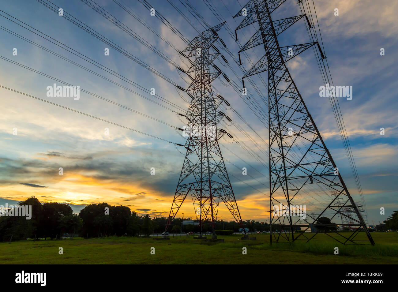 High-voltage power transmission towers in sunset sky background Stock ...
