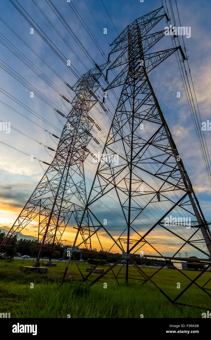 High-voltage power transmission towers in sunset sky background Stock ...