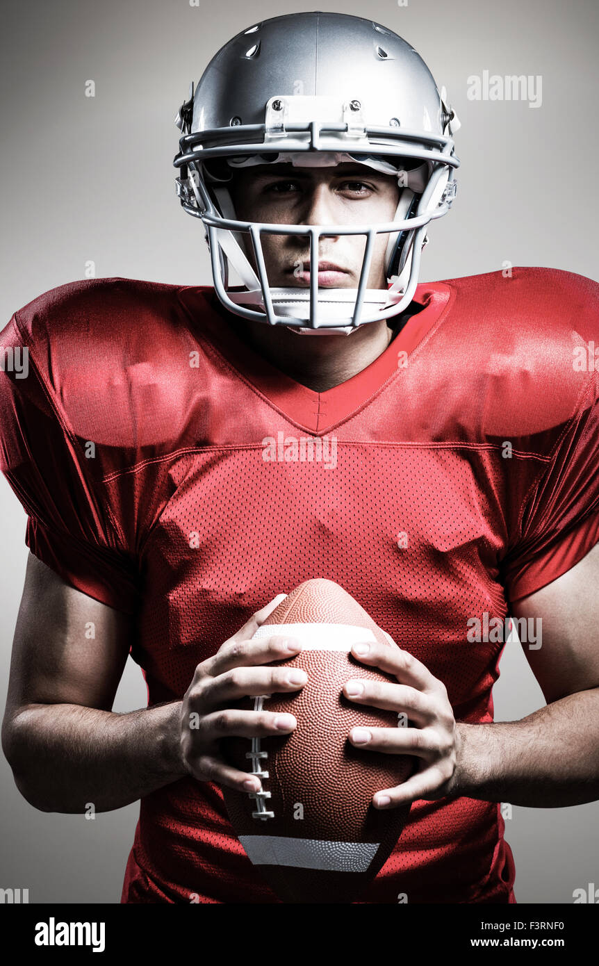 Composite image of portrait of serious american football player holding ...