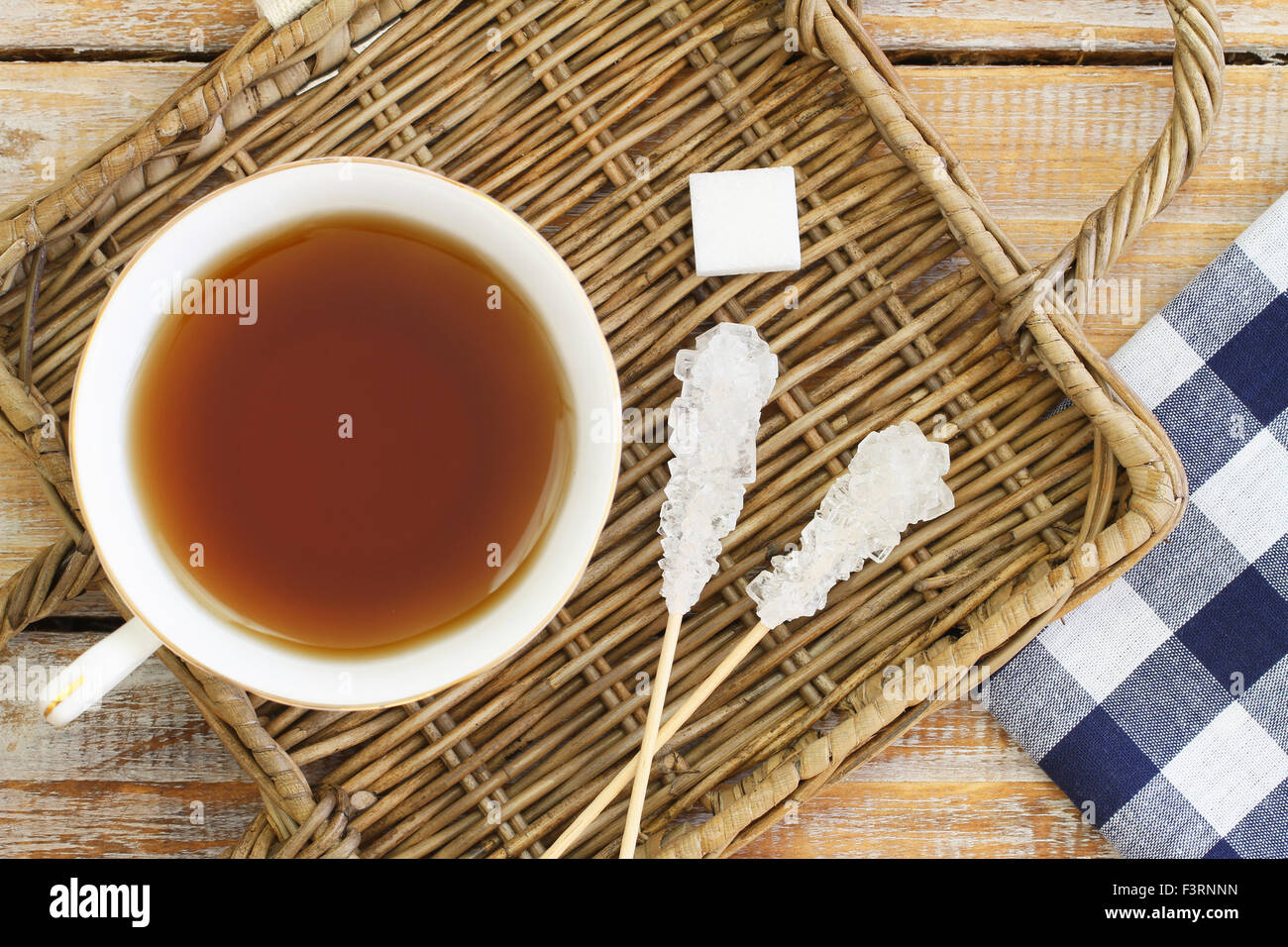 Cup of tea on wicker tray and white sugar sticks Stock Photo - Alamy